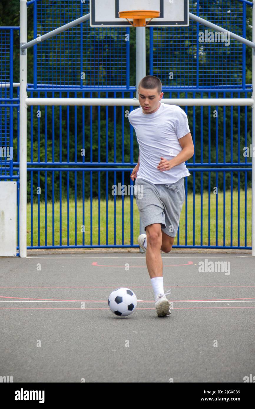 A Nineteen Year Old Teenage Boy Playing Football in A Public Park Stock ...