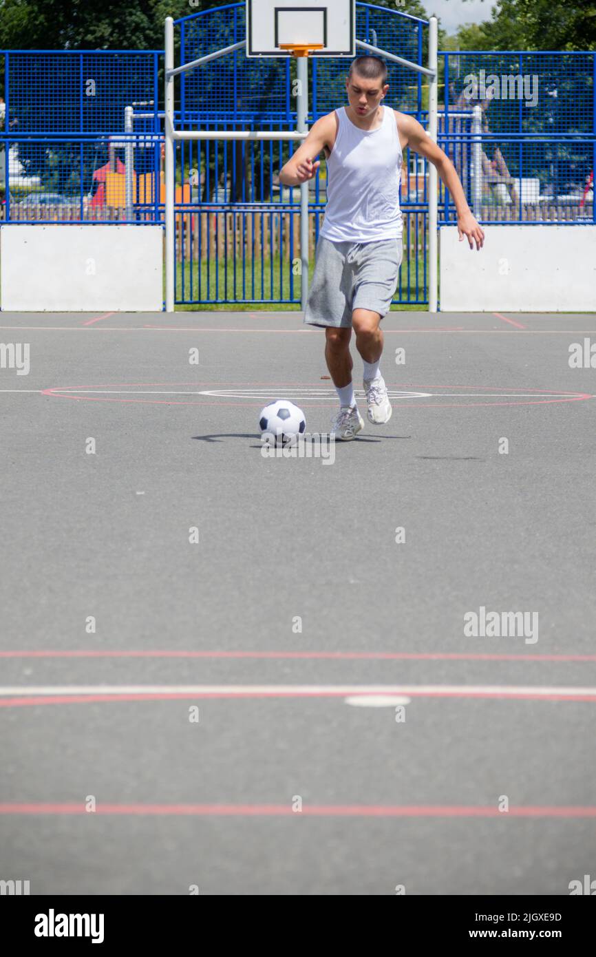 A Nineteen Year Old Teenage Boy Playing Football in A Public Park Stock Photo - Alamy
