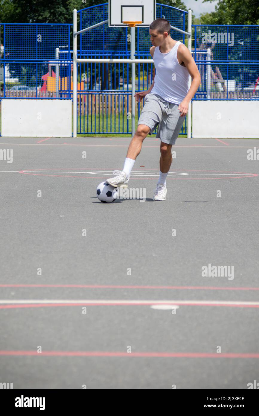 A Nineteen Year Old Teenage Boy Playing Football in A Public Park Stock ...