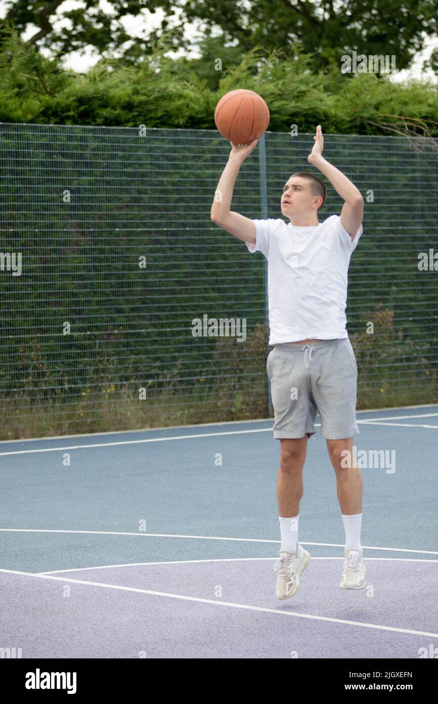 A Nineteen Year Old Teenage Boy Shooting A Hoop in A Basketball Court ...
