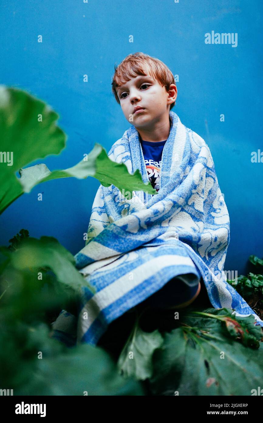 sad child sitting on the street in a blanket Stock Photo - Alamy