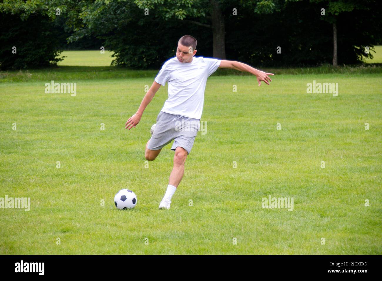 A Nineteen Year Old Teenage Boy Playing Football in A Public Park Stock Photo - Alamy