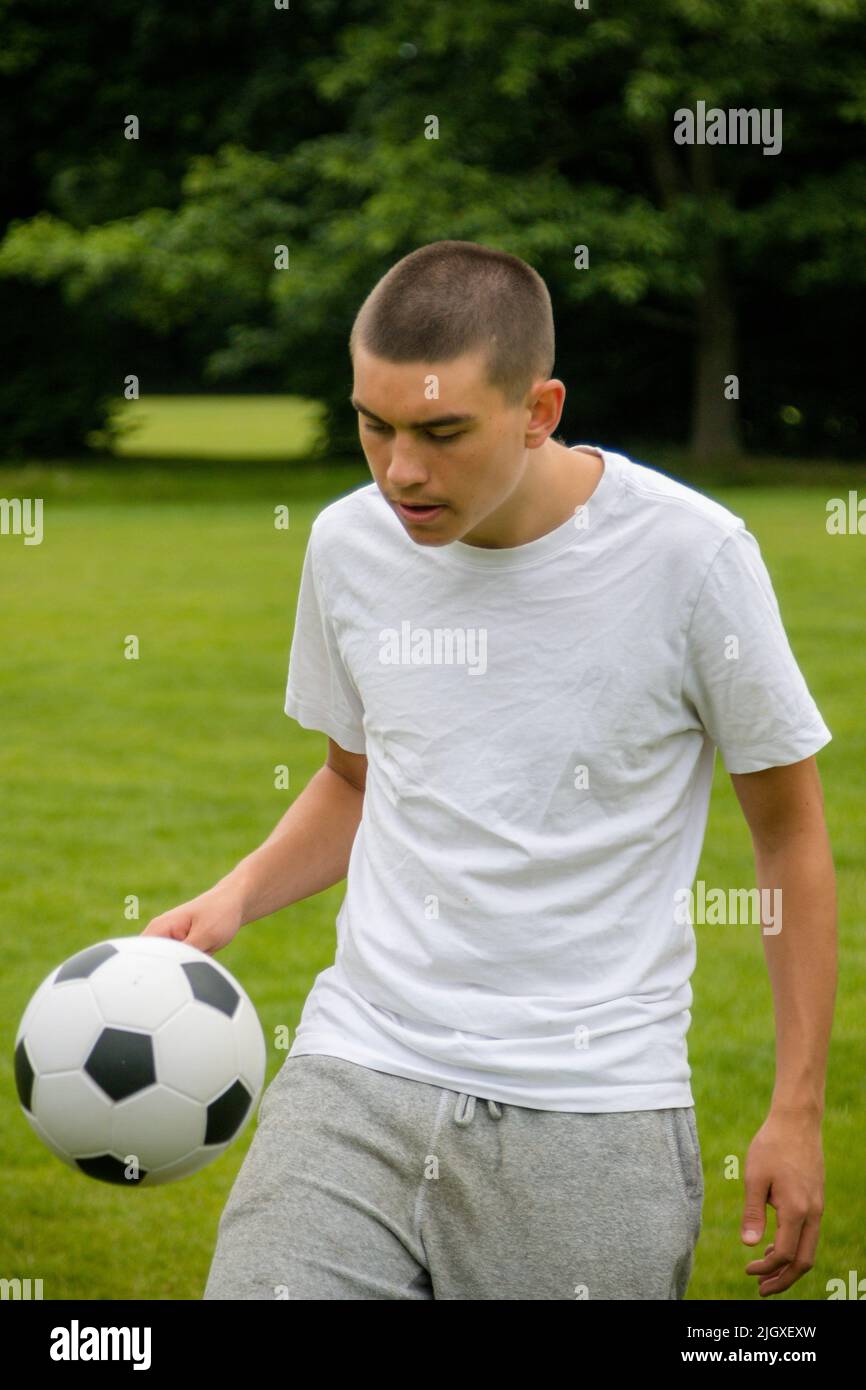 A Nineteen Year Old Teenage Boy Playing Football in A Public Park Stock ...
