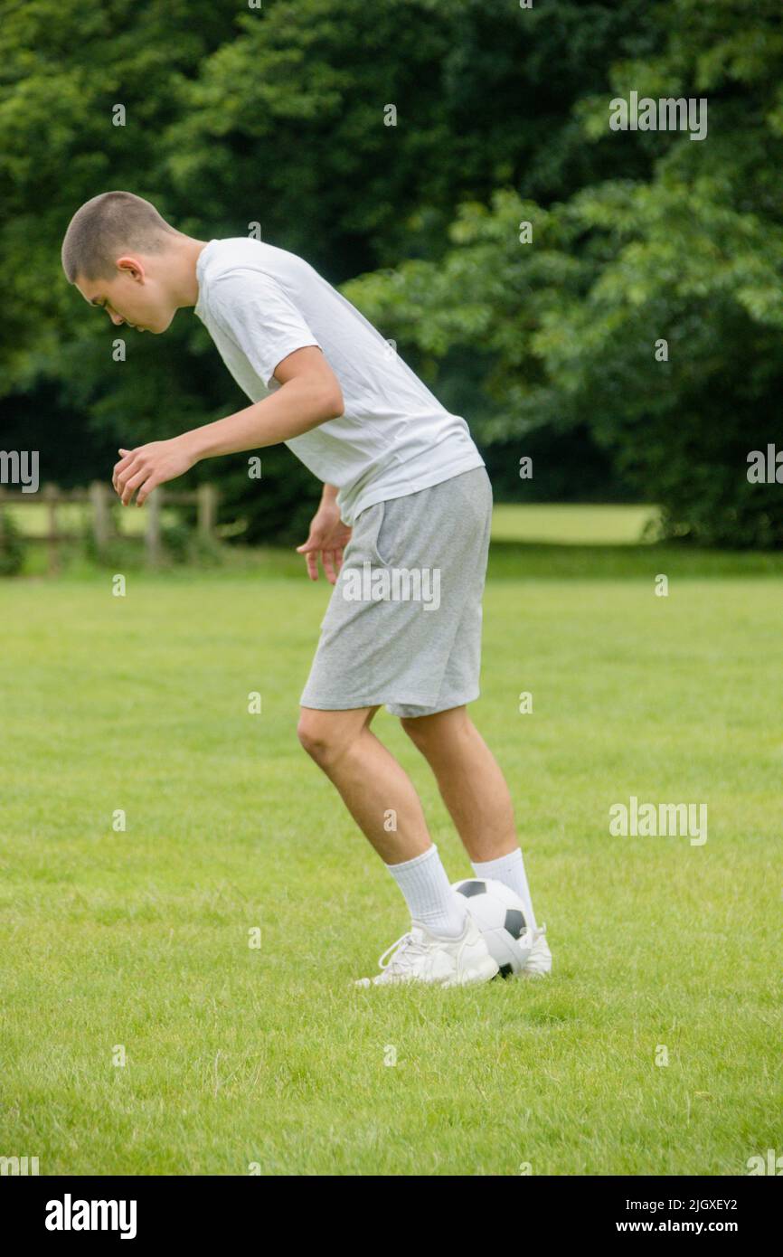 A Nineteen Year Old Teenage Boy Playing Football in A Public Park Stock ...