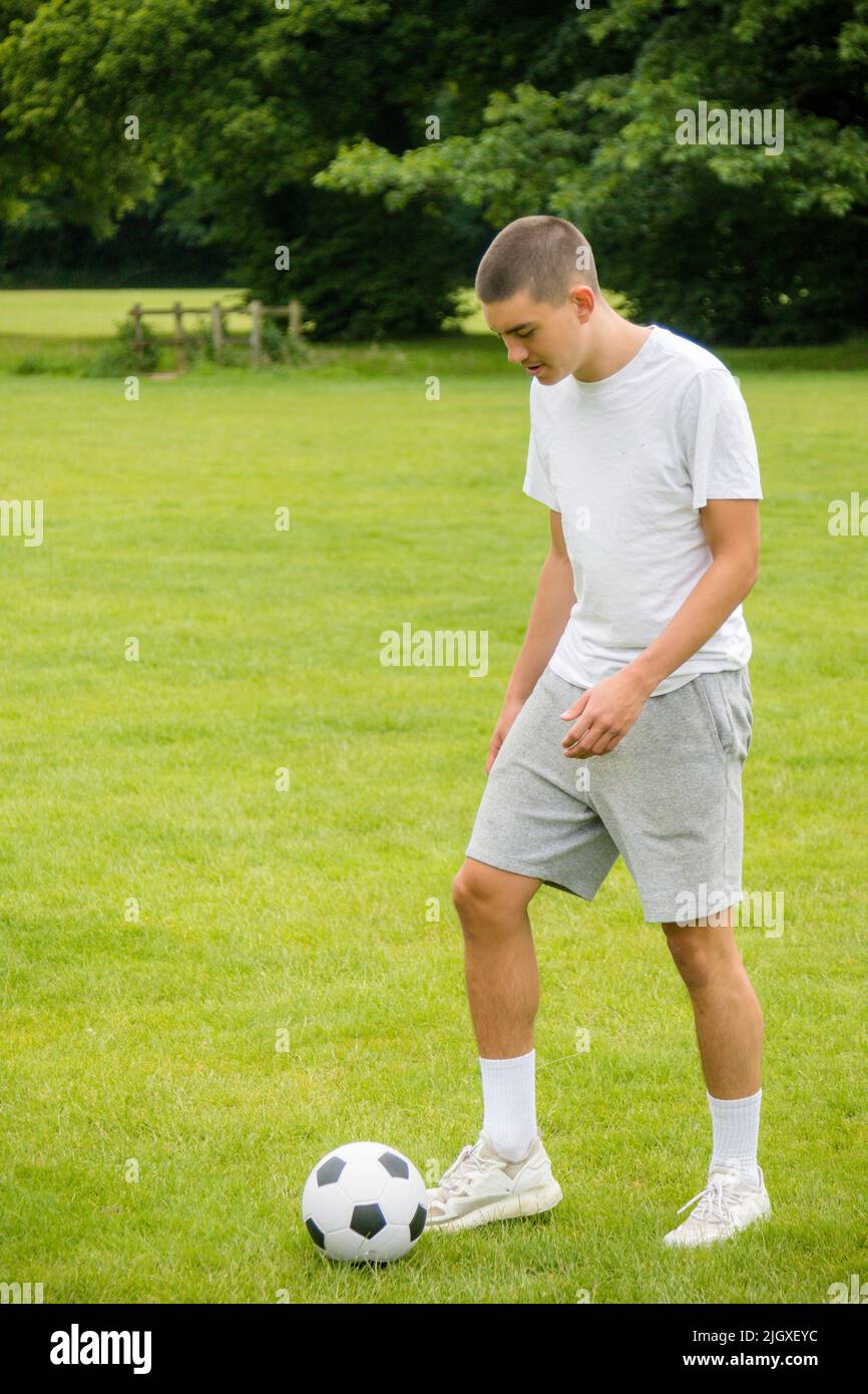 A Nineteen Year Old Teenage Boy Playing Football in A Public Park Stock ...