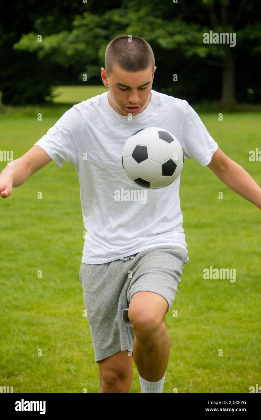A Nineteen Year Old Teenage Boy Playing Football in A Public Park Stock ...