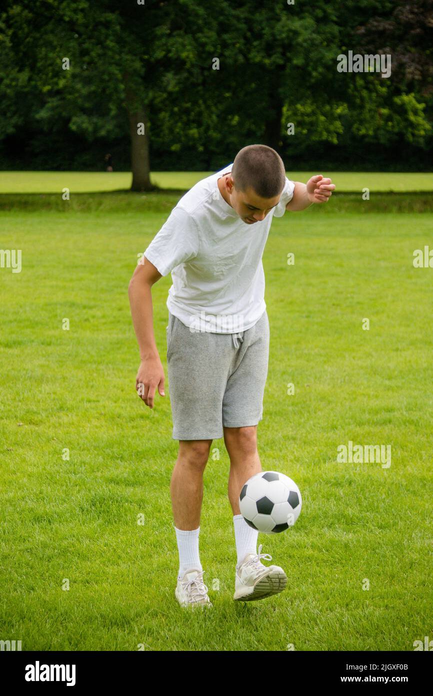 A Nineteen Year Old Teenage Boy Playing Football in A Public Park Stock Photo - Alamy