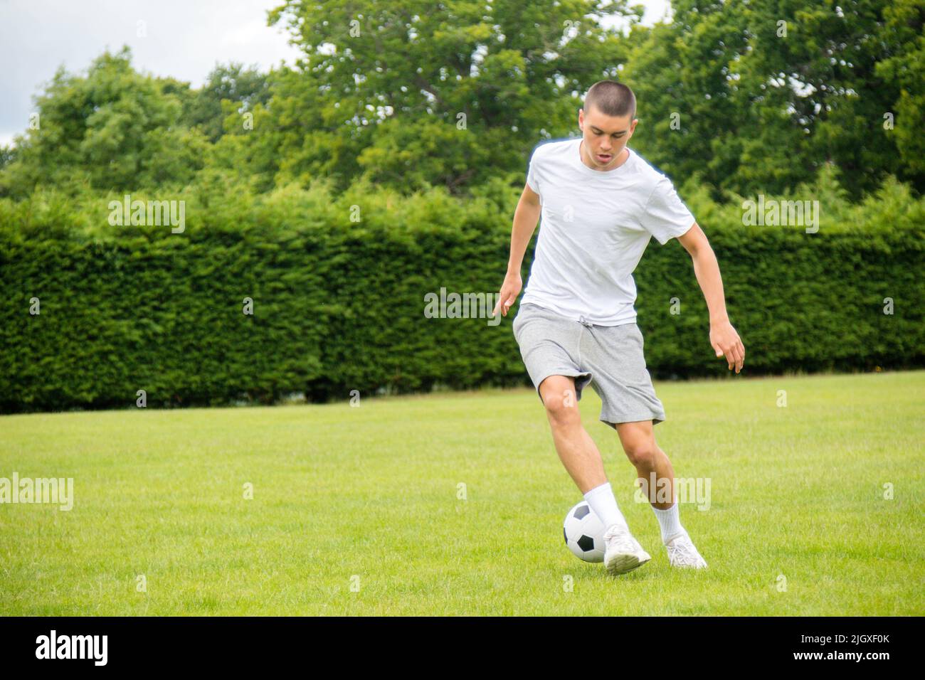 A Nineteen Year Old Teenage Boy Playing Football in A Public Park Stock ...