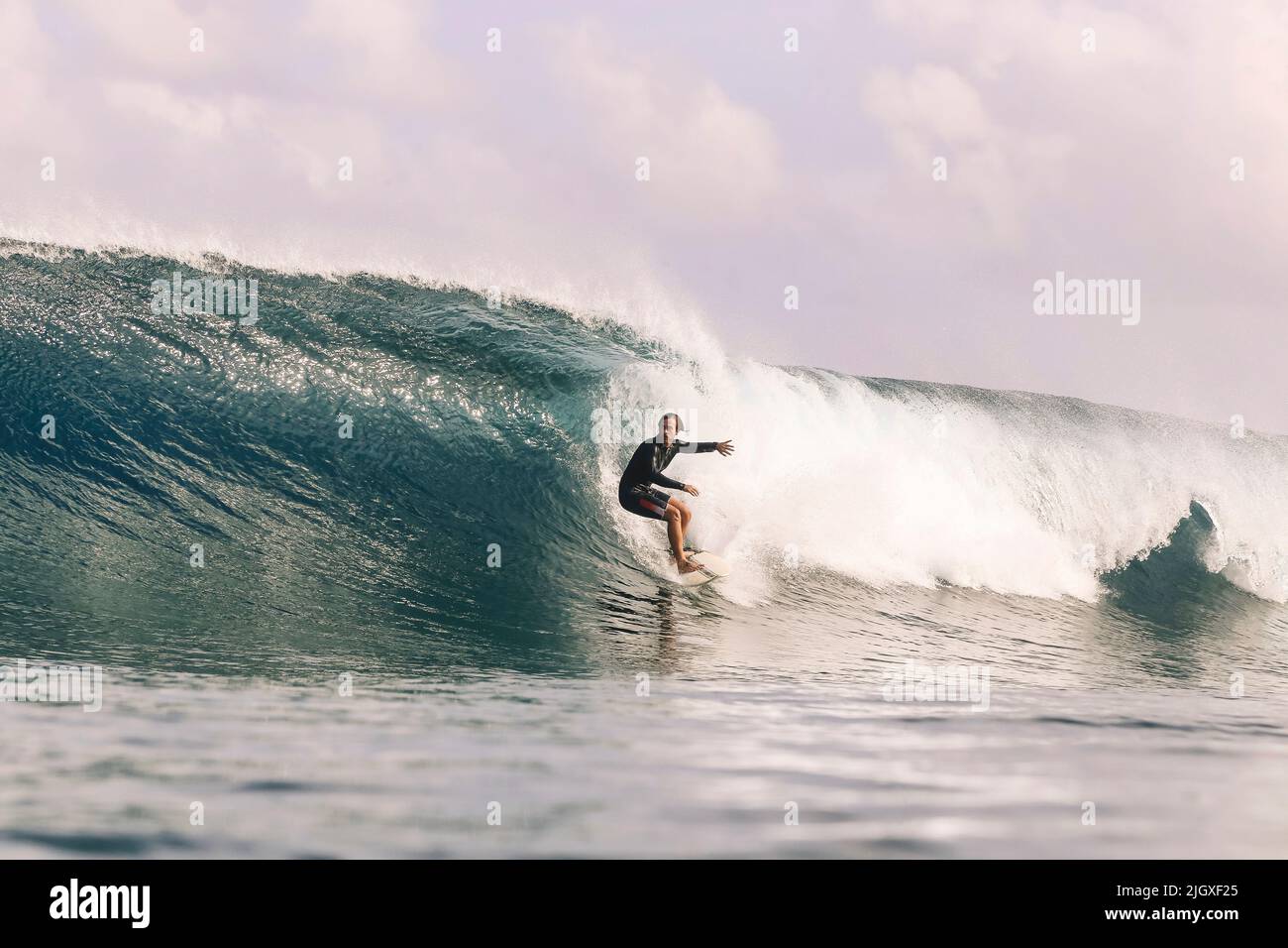 Male surfer on a wave, Maldives Stock Photo - Alamy