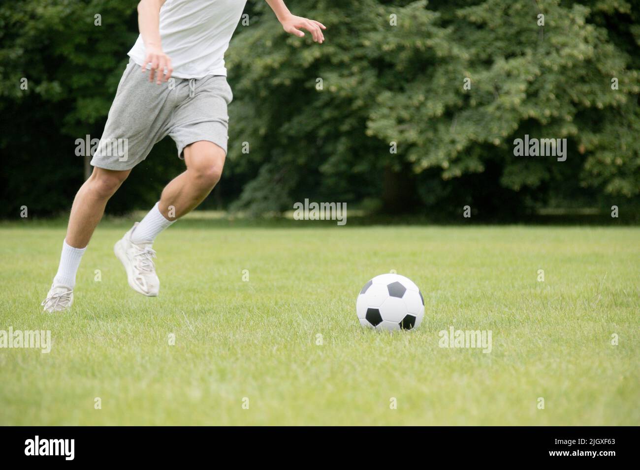A Nineteen Year Old Teenage Boy Playing Football in A Public Park Stock ...