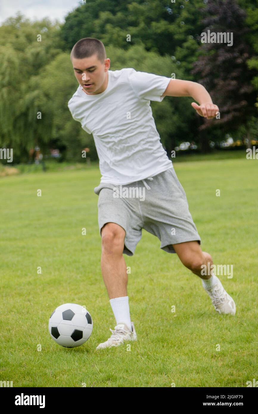 A Nineteen Year Old Teenage Boy Playing Football in A Public Park Stock ...