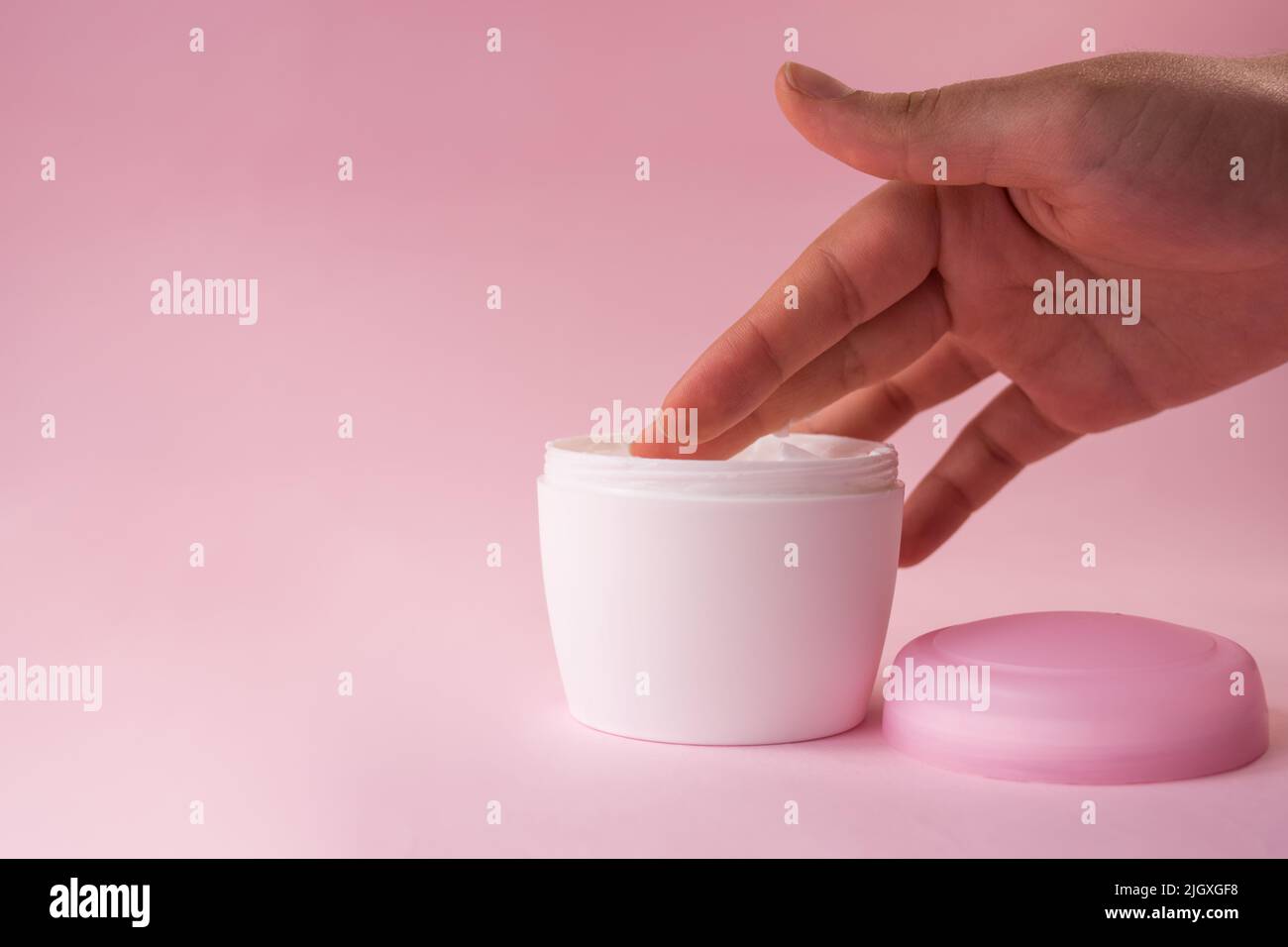 Hand taking cream from a skin cream bottle for women Stock Photo - Alamy