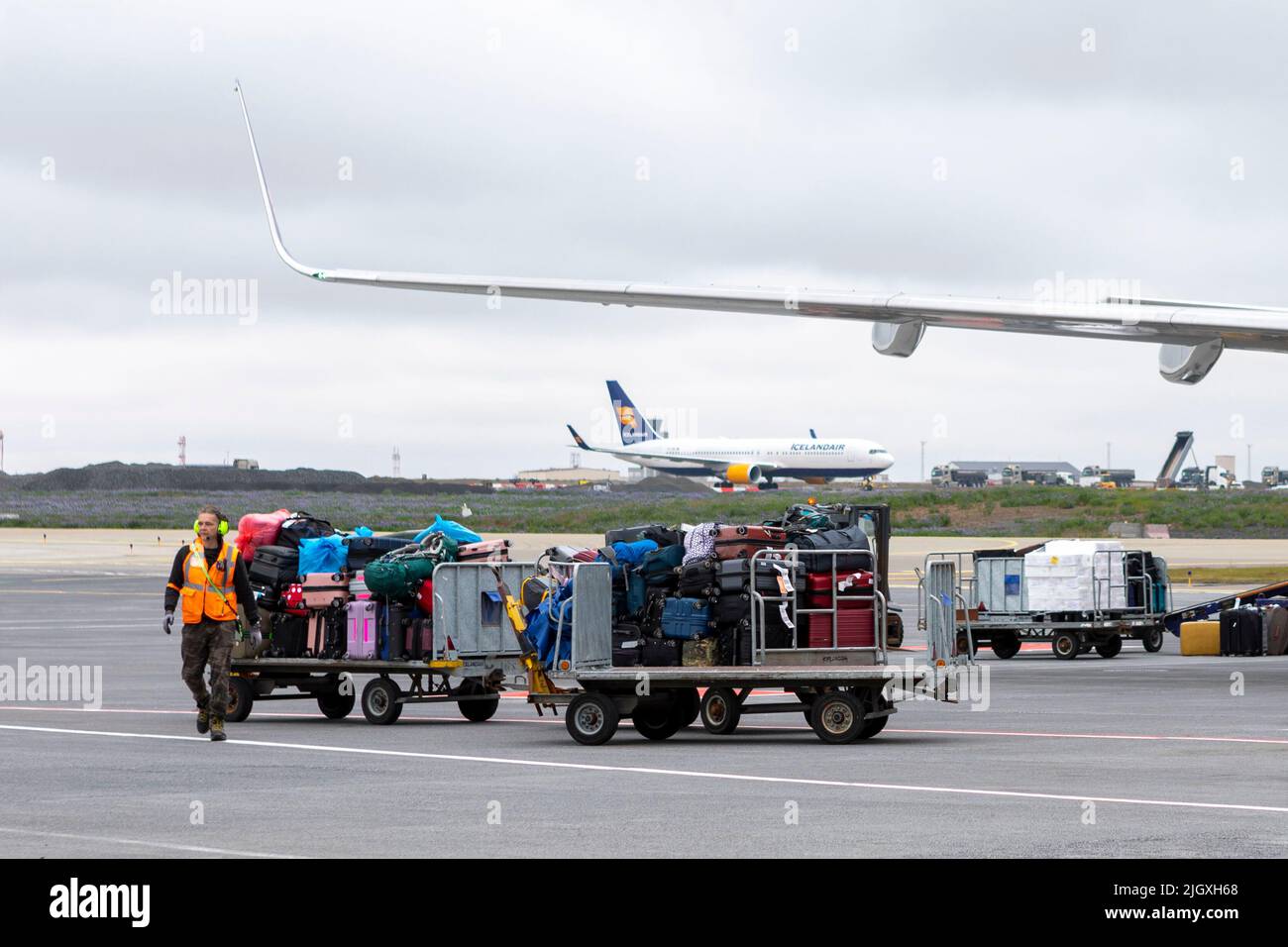 Staff at Keflavík (KEF) airport load baggage onto a plane. Image shot ...