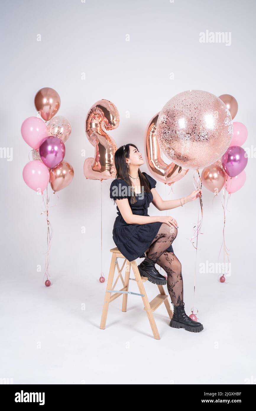 cute young asian woman holding a big balloon with confetti Stock Photo ...