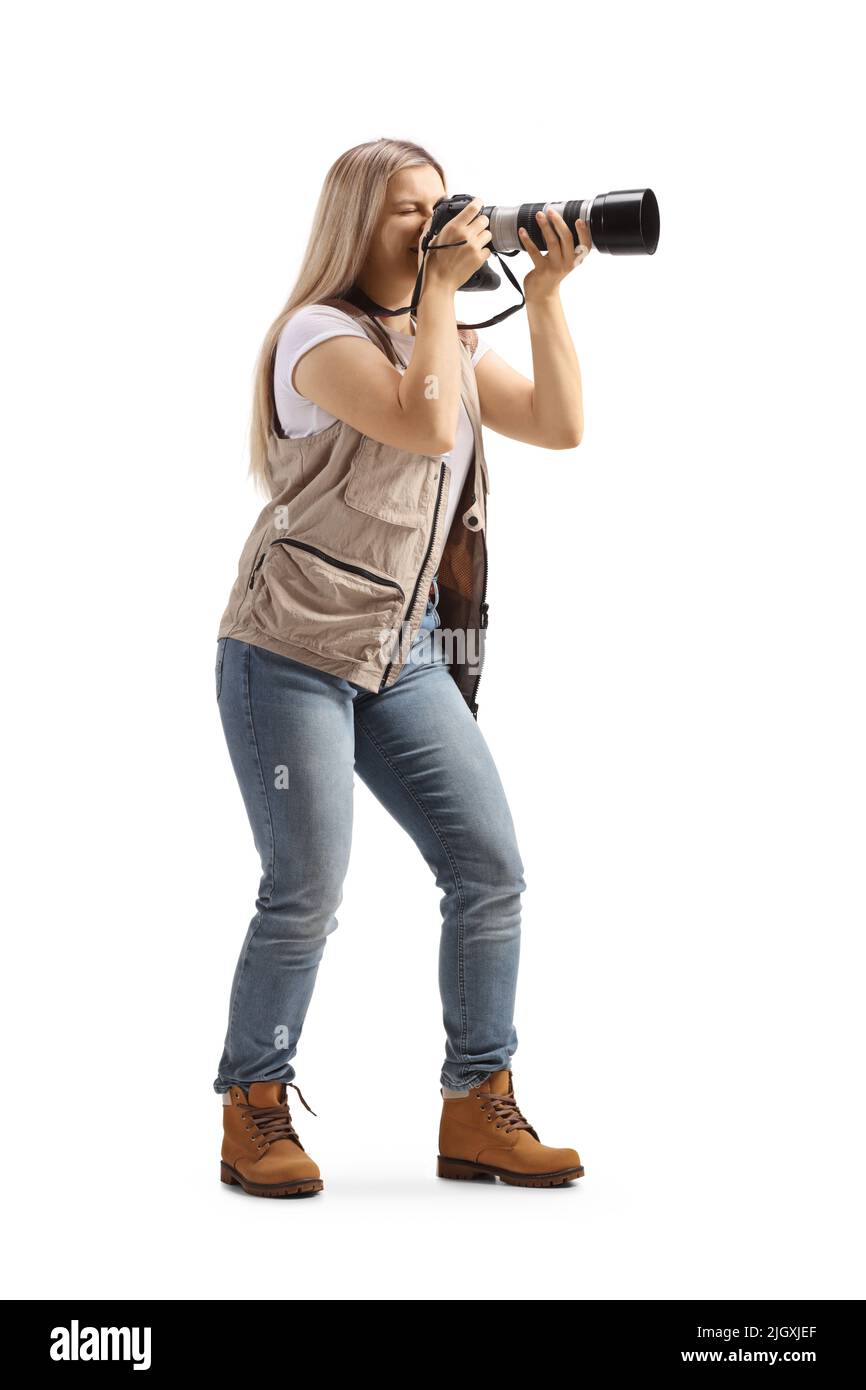 Full length shot of a female photo journalist taking a photo with a ...