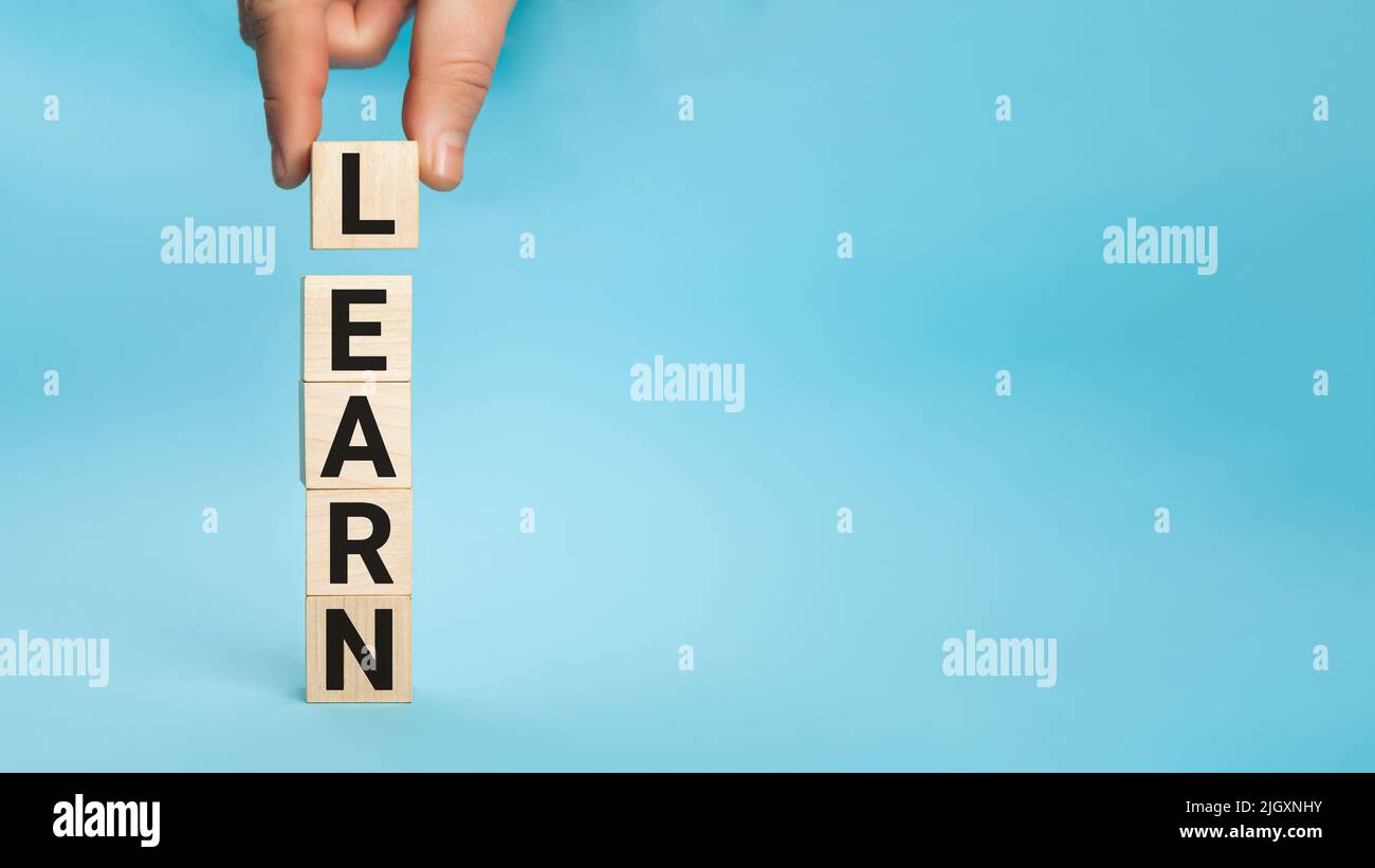 Learn or earn Hand lifts a dice and changes the word learn to earn ...