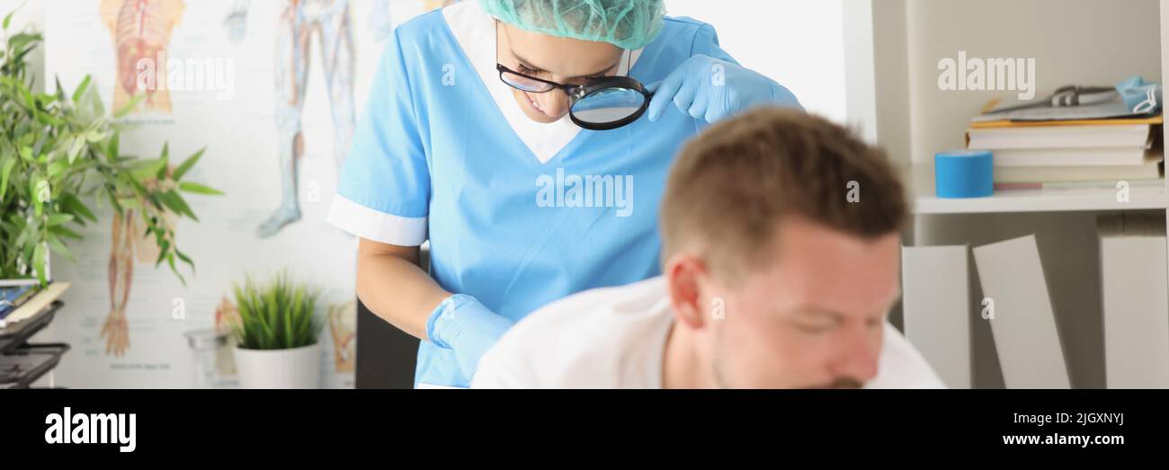 Dermatologist doctor examines mole on patients body with magnifying ...