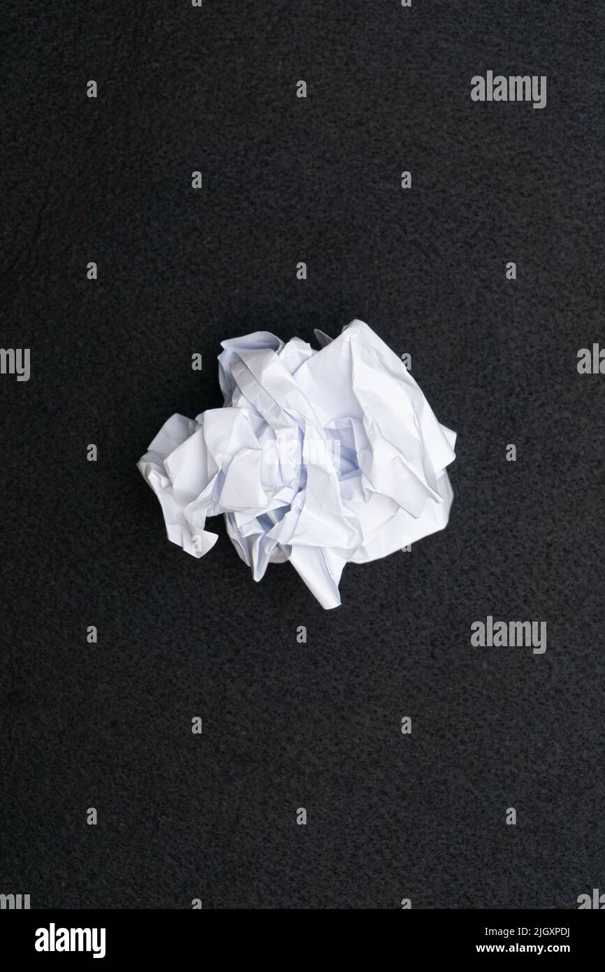 A mess of crumpled paper trash on a black background Stock Photo - Alamy