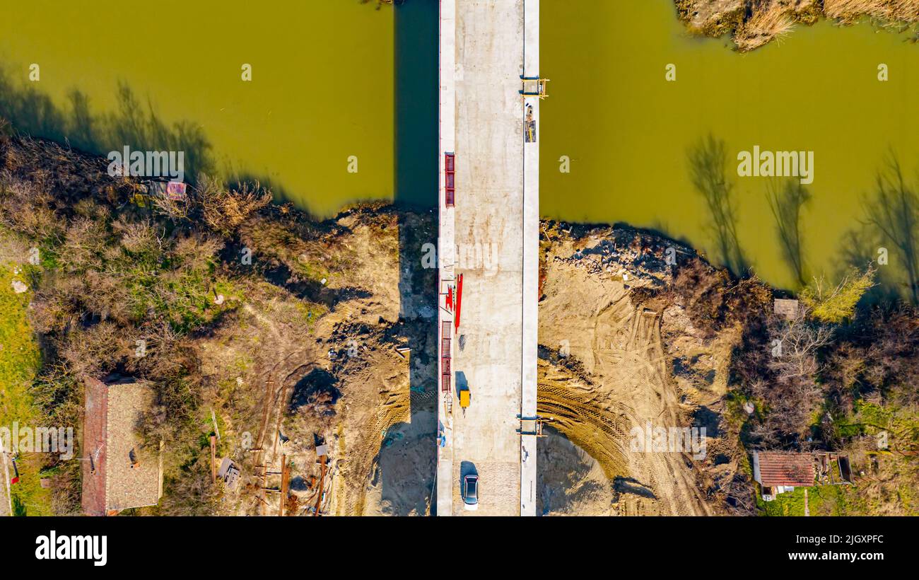 Above top view, overhead, on unfinished bridge, road over river under ...
