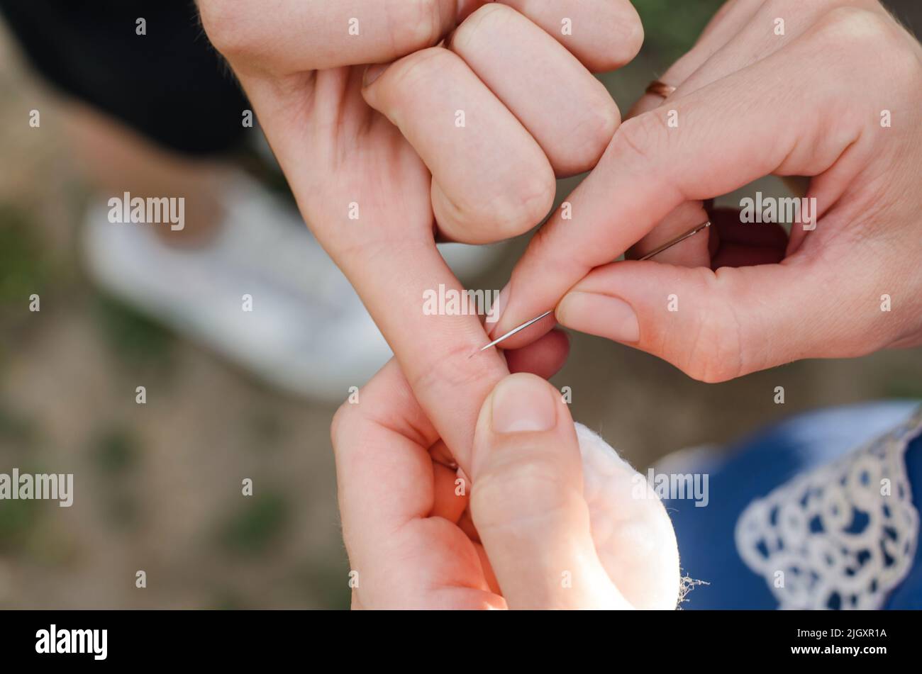 A splinter in a child's hand. The woman is trying to pull the splinter ...
