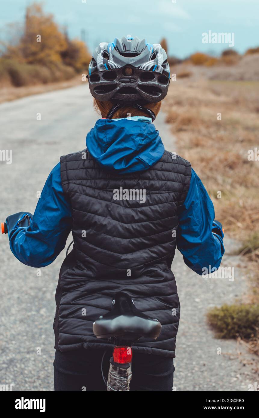 Girl cyclist back view. The girl travels by bike. A girl stands on the ...