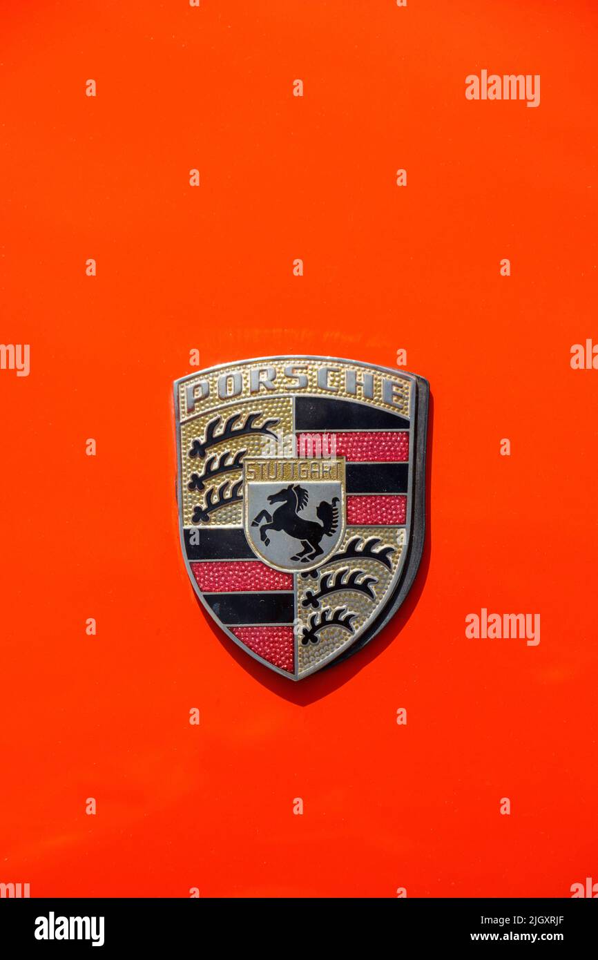close up of Porsche logo bonnet badge on red paintwork Stock Photo - Alamy