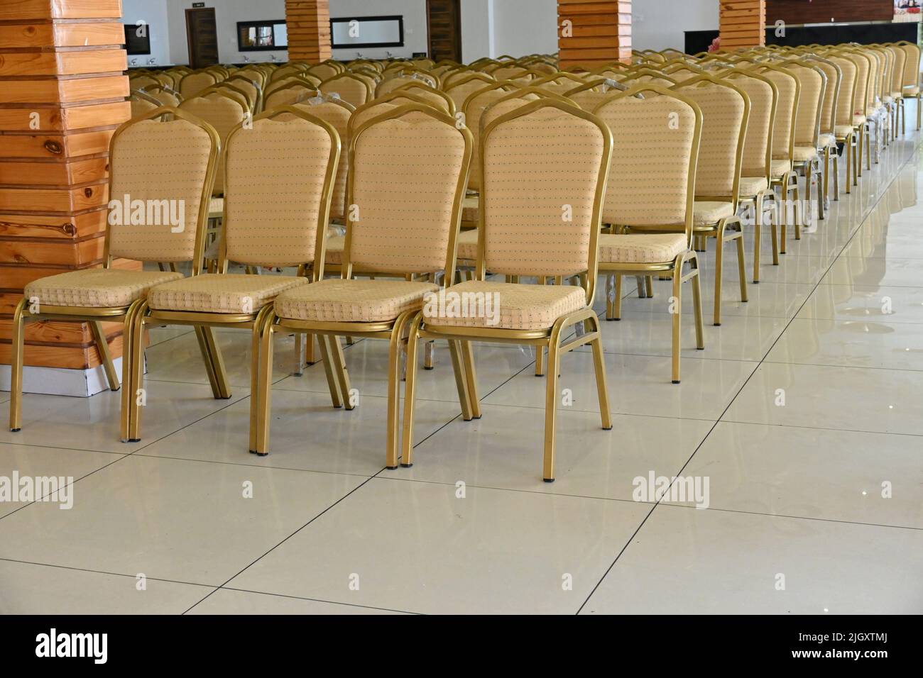 closeup the bunch yellow golden metal chairs in the row soft focus ...