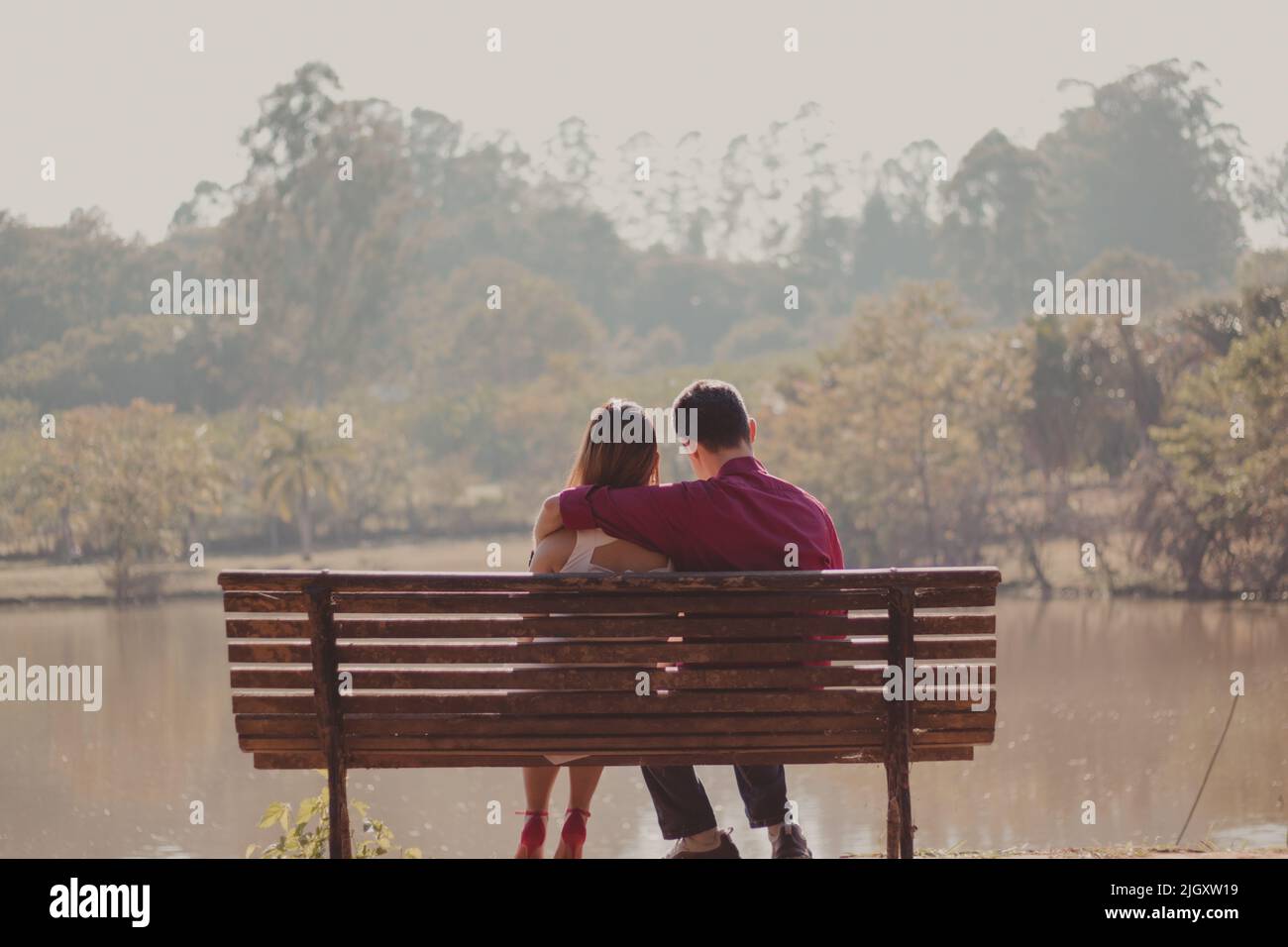couple in love sitting on park bench Stock Photo - Alamy