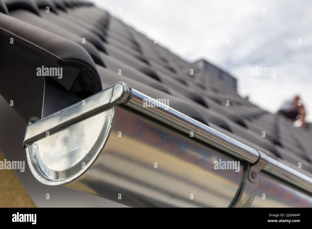 Roof gutter on a new tiled roof Stock Photo - Alamy