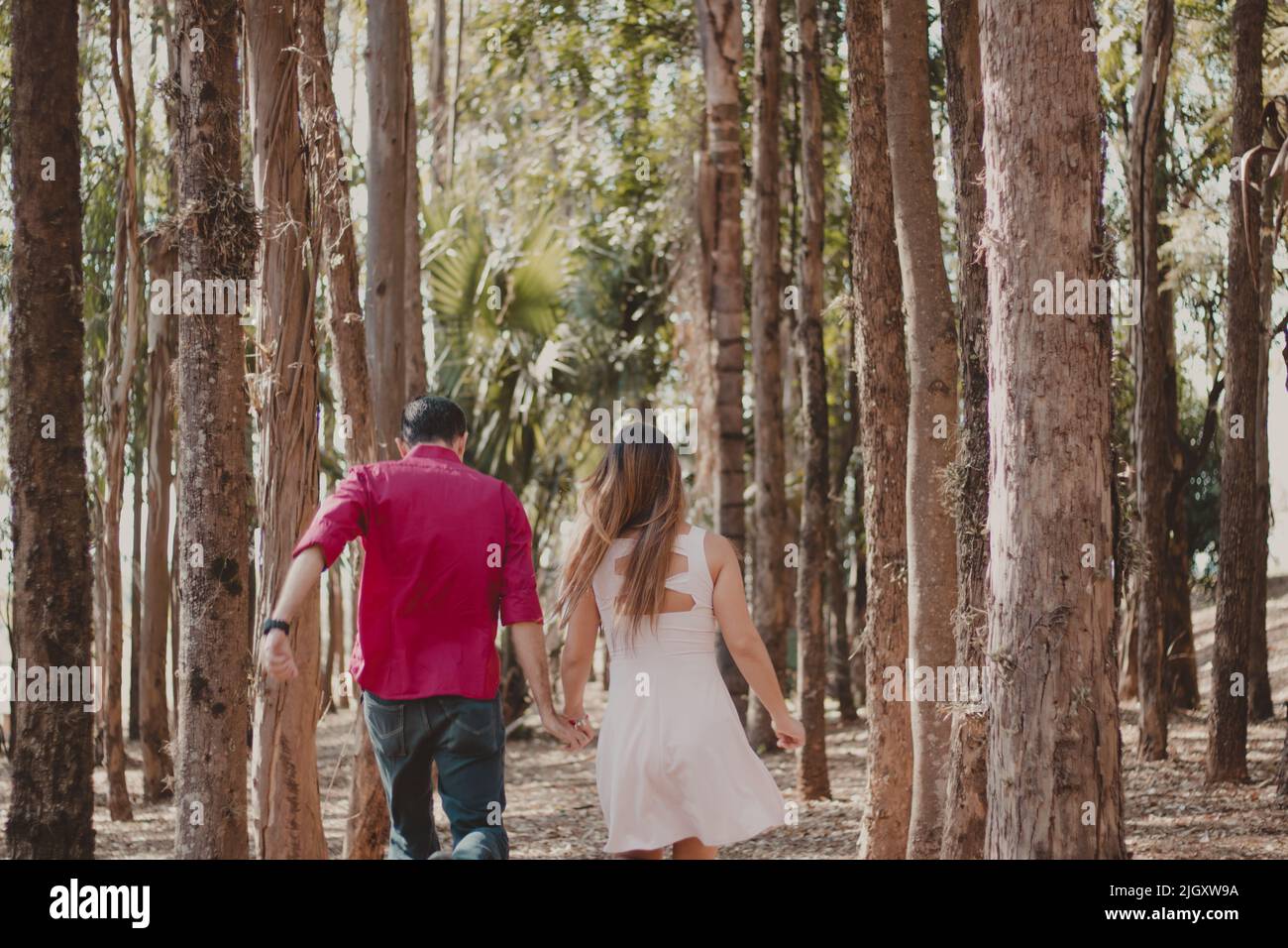 cute couple back to back running in the forest Stock Photo - Alamy