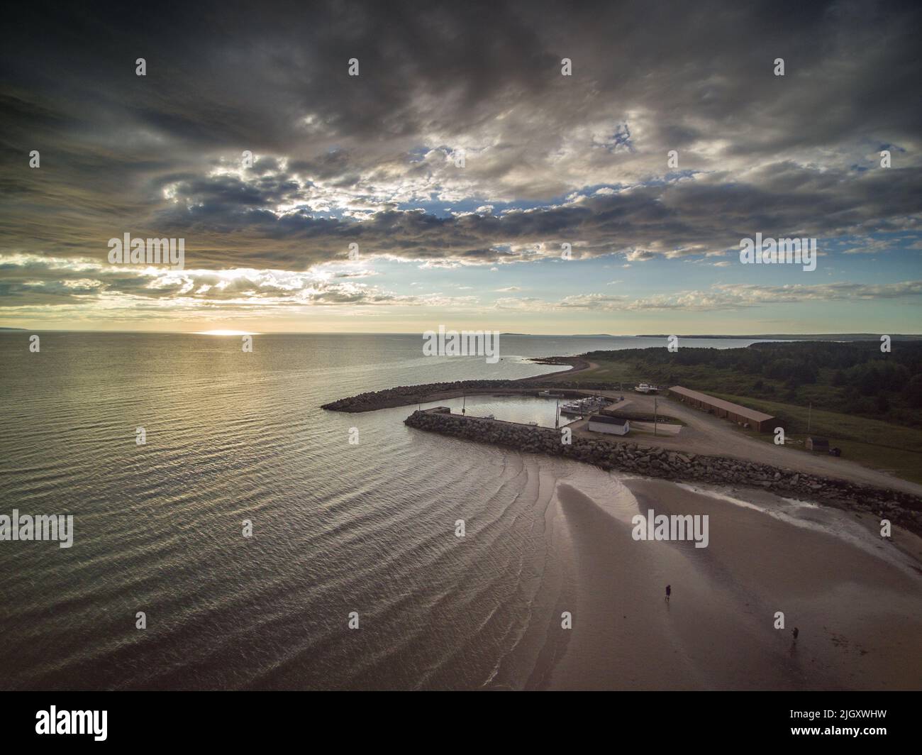 An aerial view of a sandy shore with buildings and stone-made piers ...