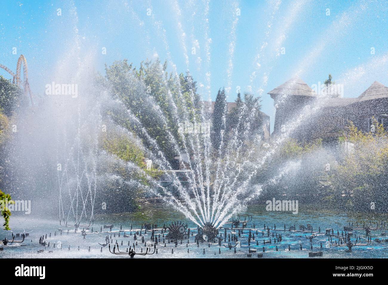 Powerful streams of a fan-shaped fountain beat in the middle of shallow ...