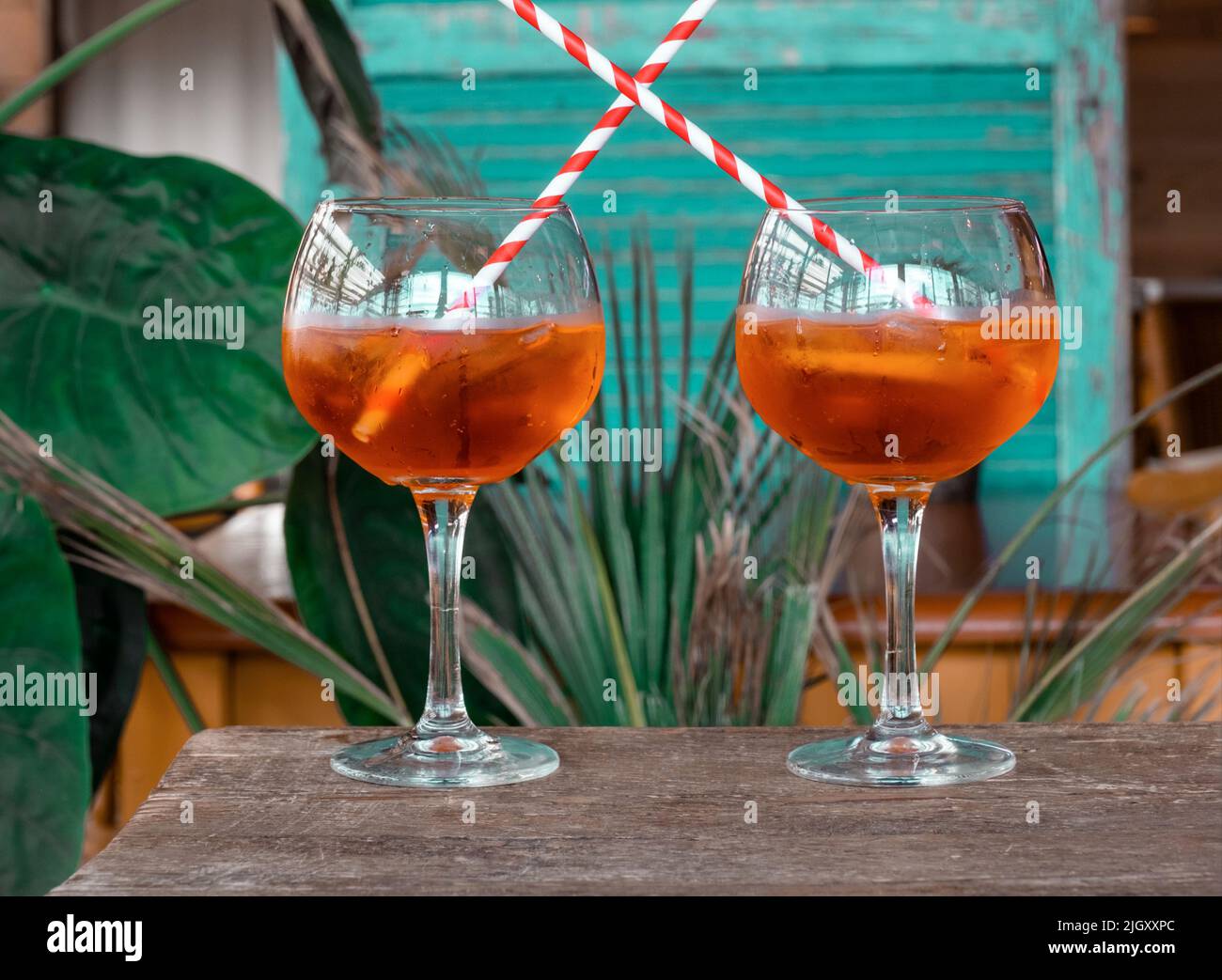 Aperol spritz cocktail in glass on the old wooden table on the green ...