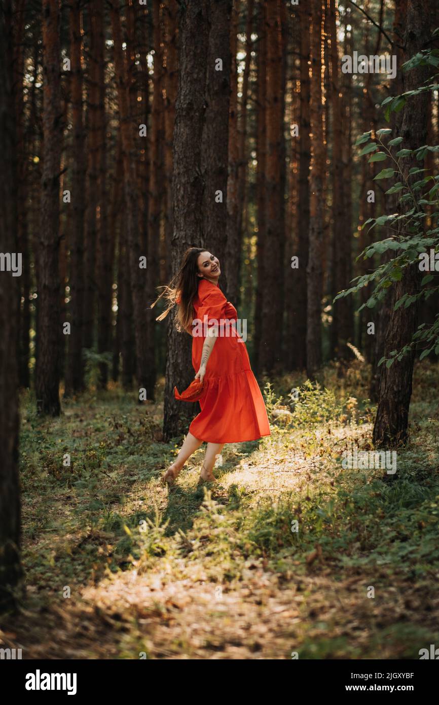 Peace of mind, breathing fresh air. Alone woman in red dress enjoys the ...