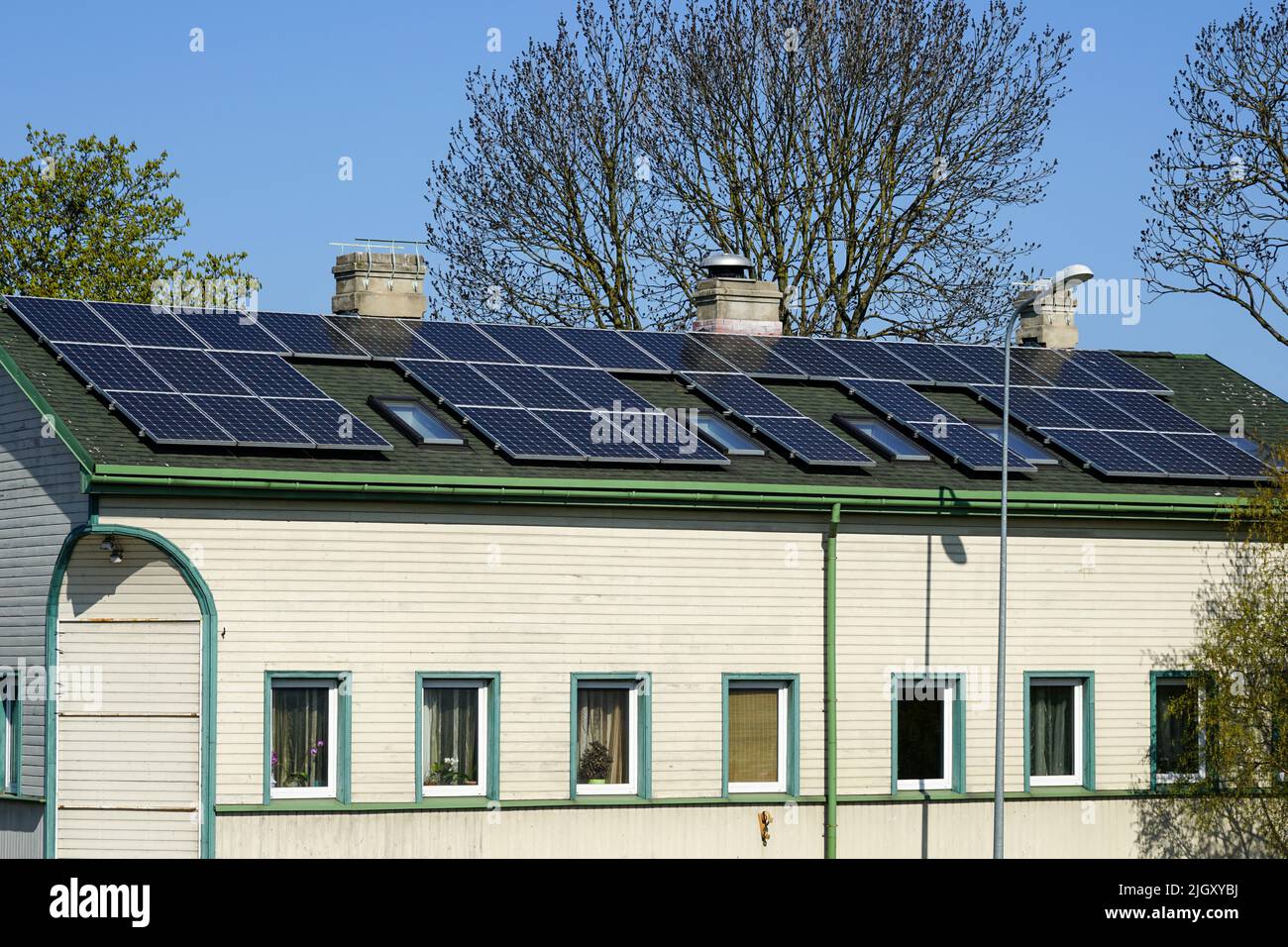 Many photovoltaic solar panels mounted on the old large wooden house ...
