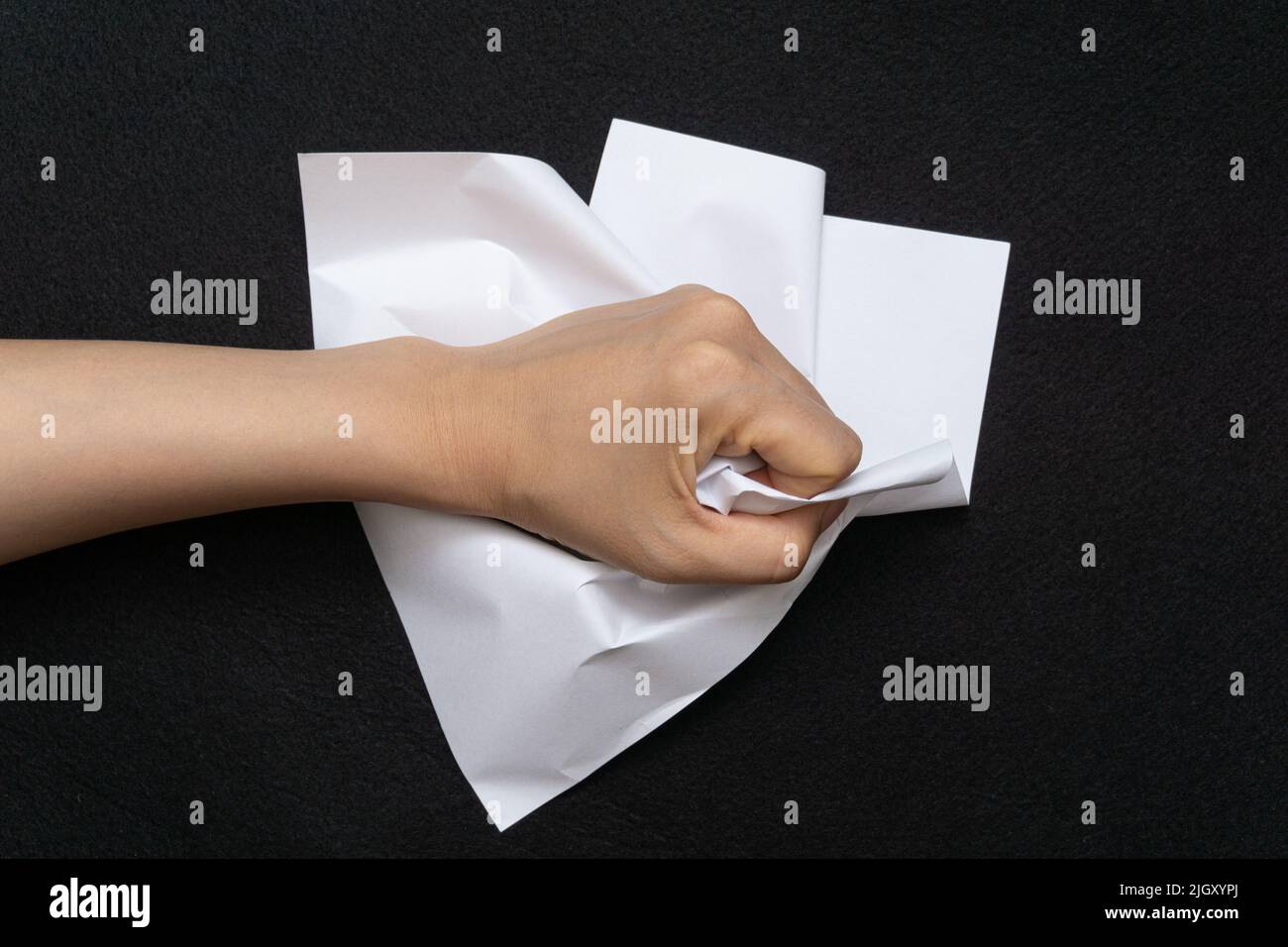 A mess of crumpled paper trash on a black background Stock Photo - Alamy