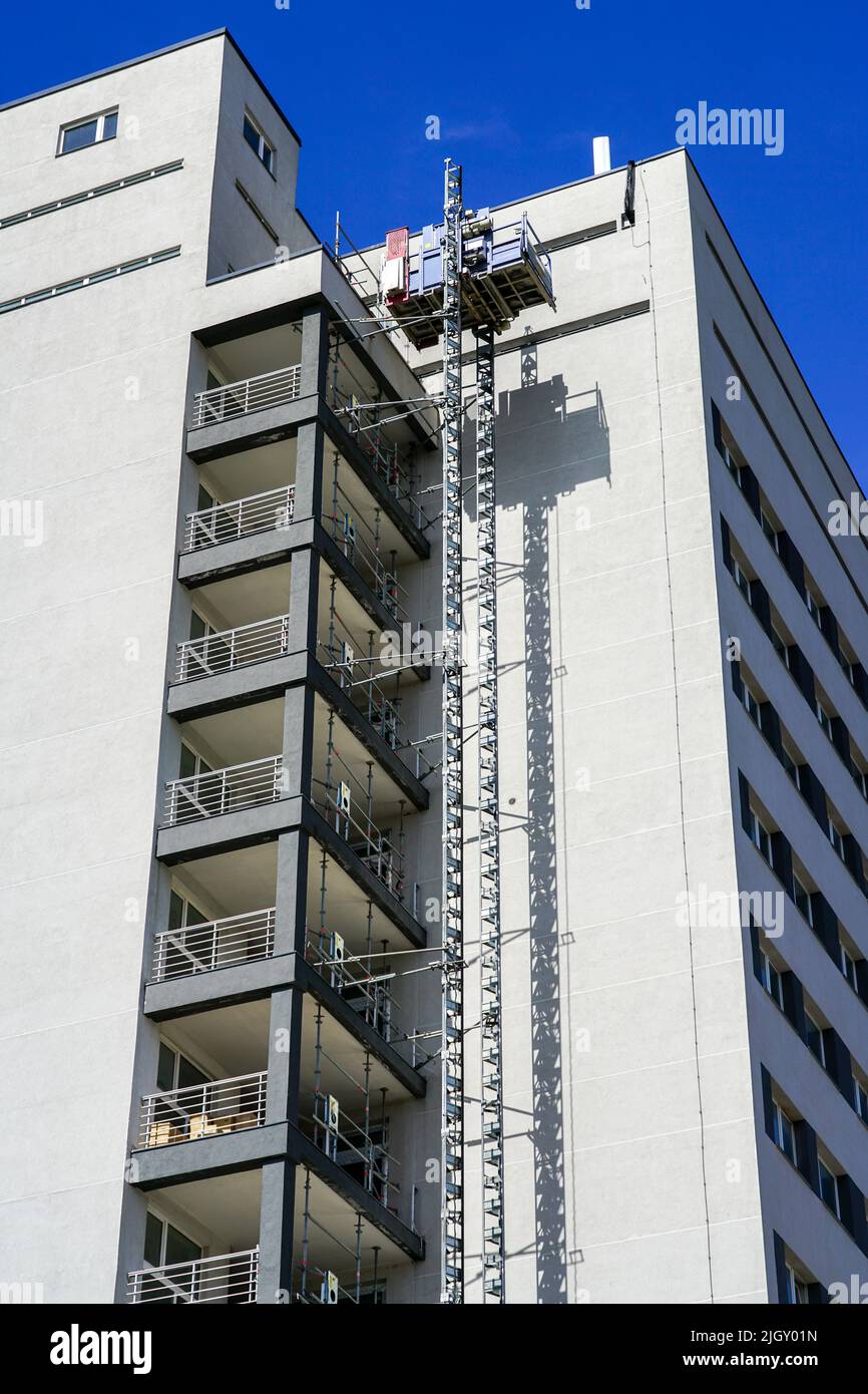 A very high modern self propelled exterior freight elevator attached to ...
