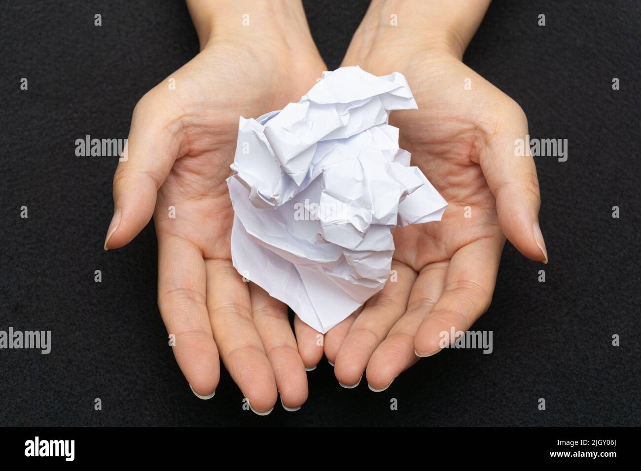 A mess of crumpled paper trash on a black background Stock Photo - Alamy