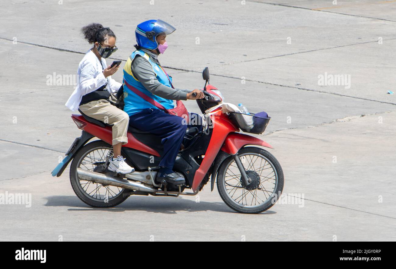 SAMUT PRAKAN, THAILAND, MAR 29 2022, A taxi driver on a motorcycle ... SAMUT PRAKAN, THAILAND, MAR 29 2022, A taxi driver on a motorcycle ...