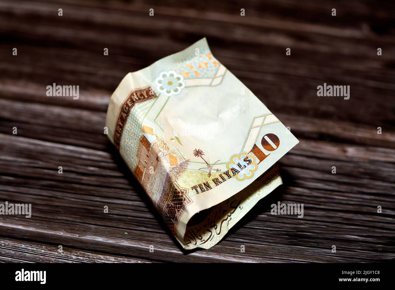 Folded Saudi Arabia money of 10 SAR ten riyals isolated on wooden ...