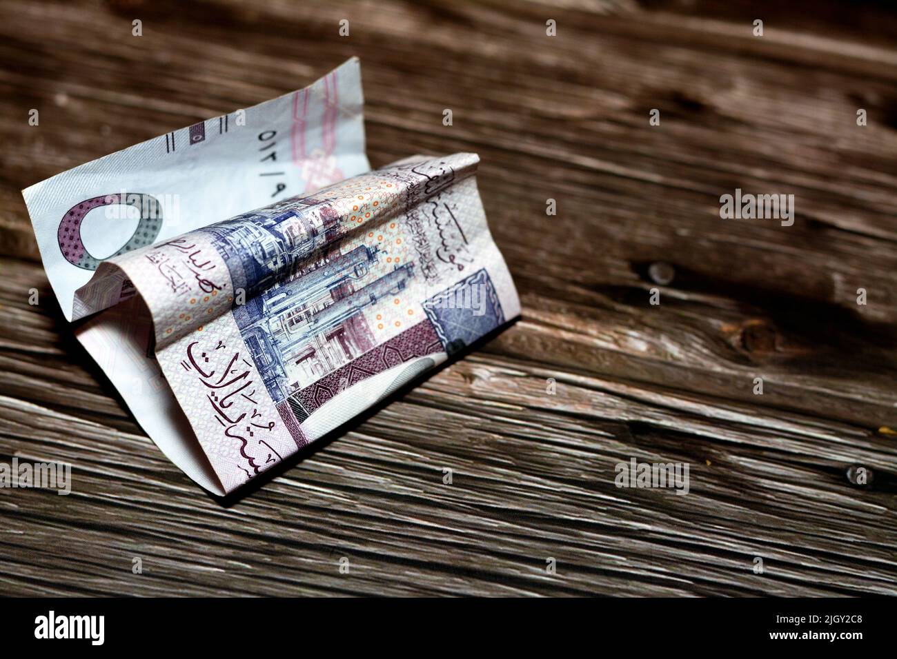 Folded Saudi Arabia money of 5 SAR five riyals isolated on wooden ...
