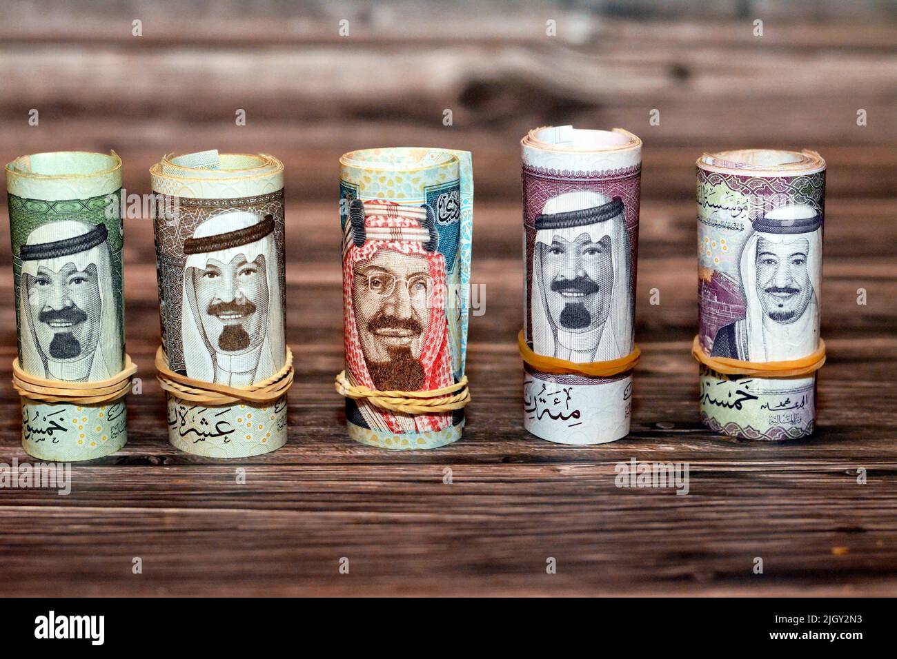 Saudi Arabia money roll riyals banknotes isolated on wooden background ...