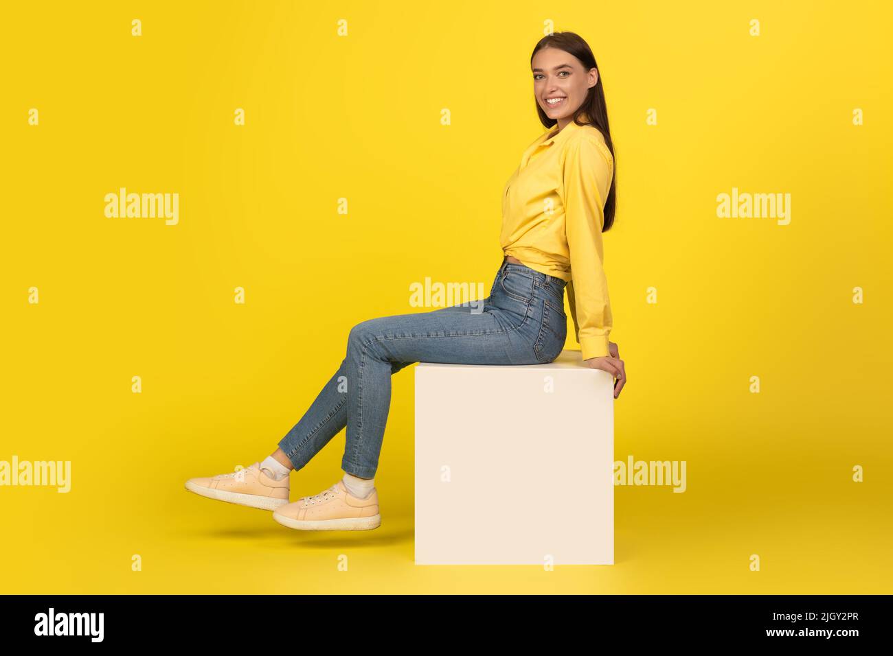 Female model sitting on cube hi-res stock photography and images - Alamy