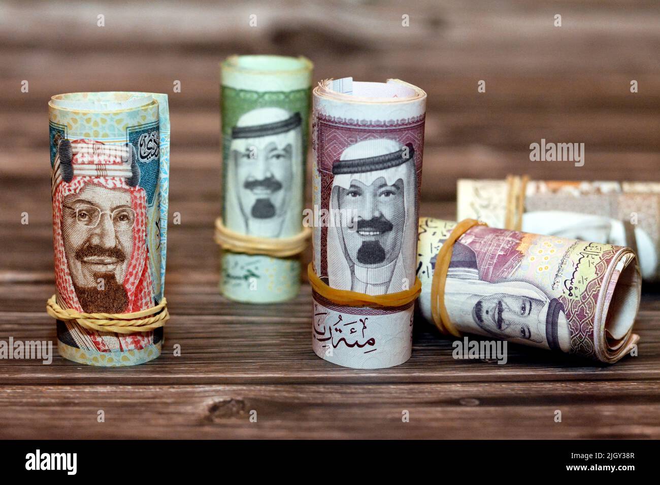 Saudi Arabia money roll riyals banknotes isolated on wooden background ...