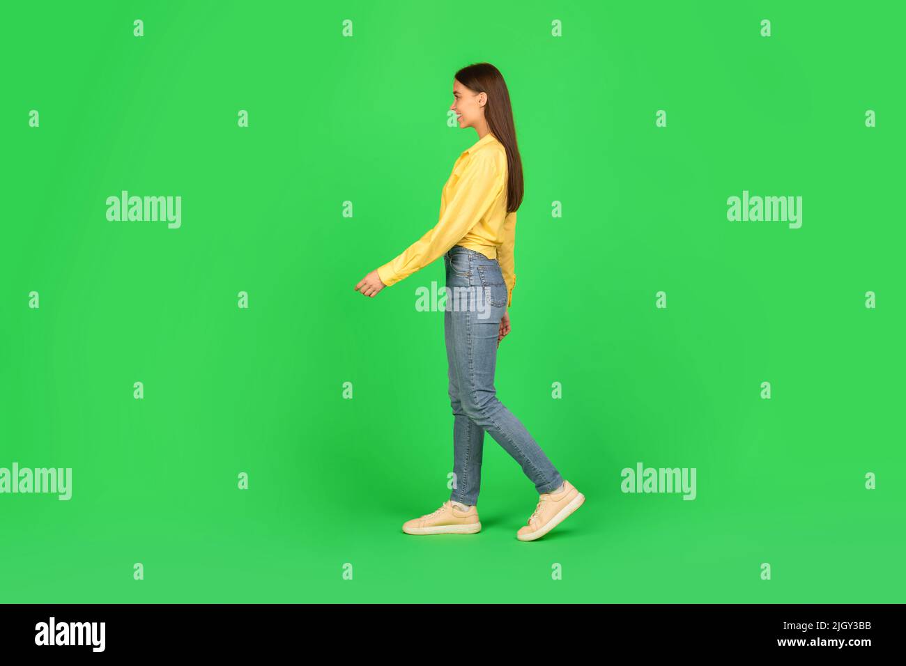 Side View Of Cheerful Woman Walking Posing Over Green Background Stock ...