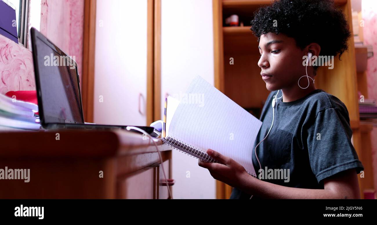 Child studying at home during quarantine in front of laptop computer ...