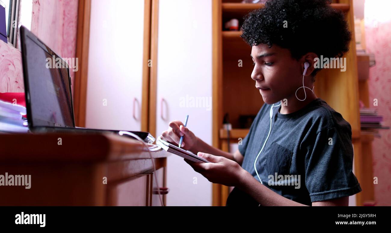 Child studying at home during quarantine in front of laptop computer ...
