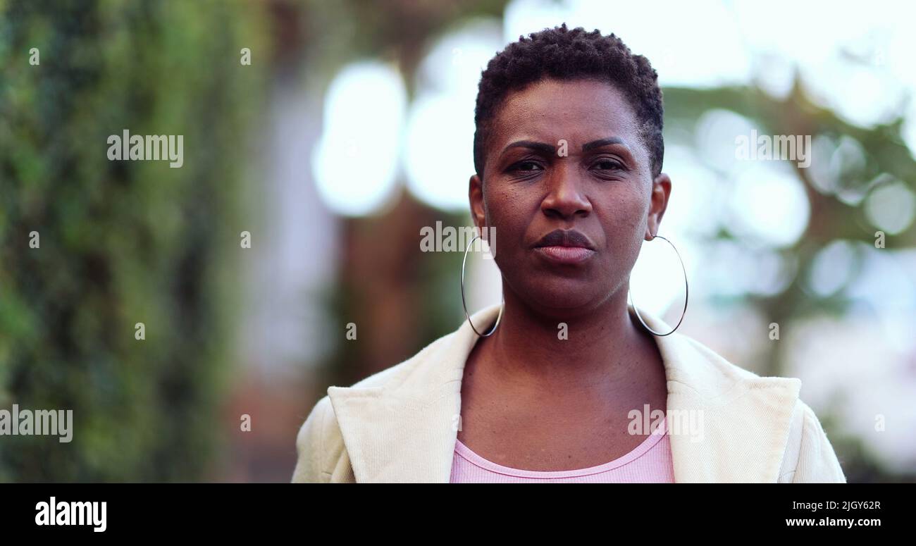 Confident serious African woman 40s walking towards camera in street ...