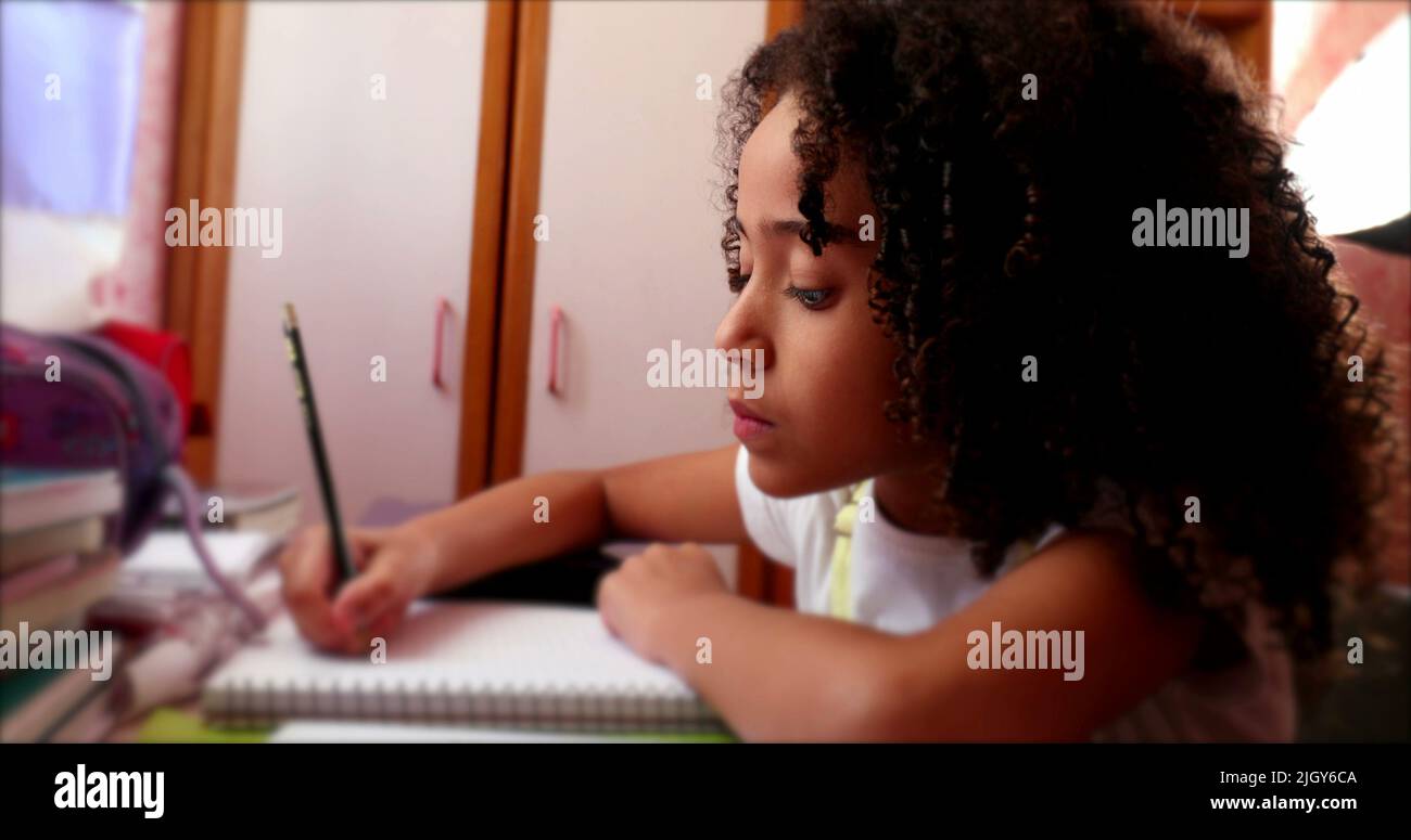 Ethnically diverse little girl child writing notes with pen. kid ...