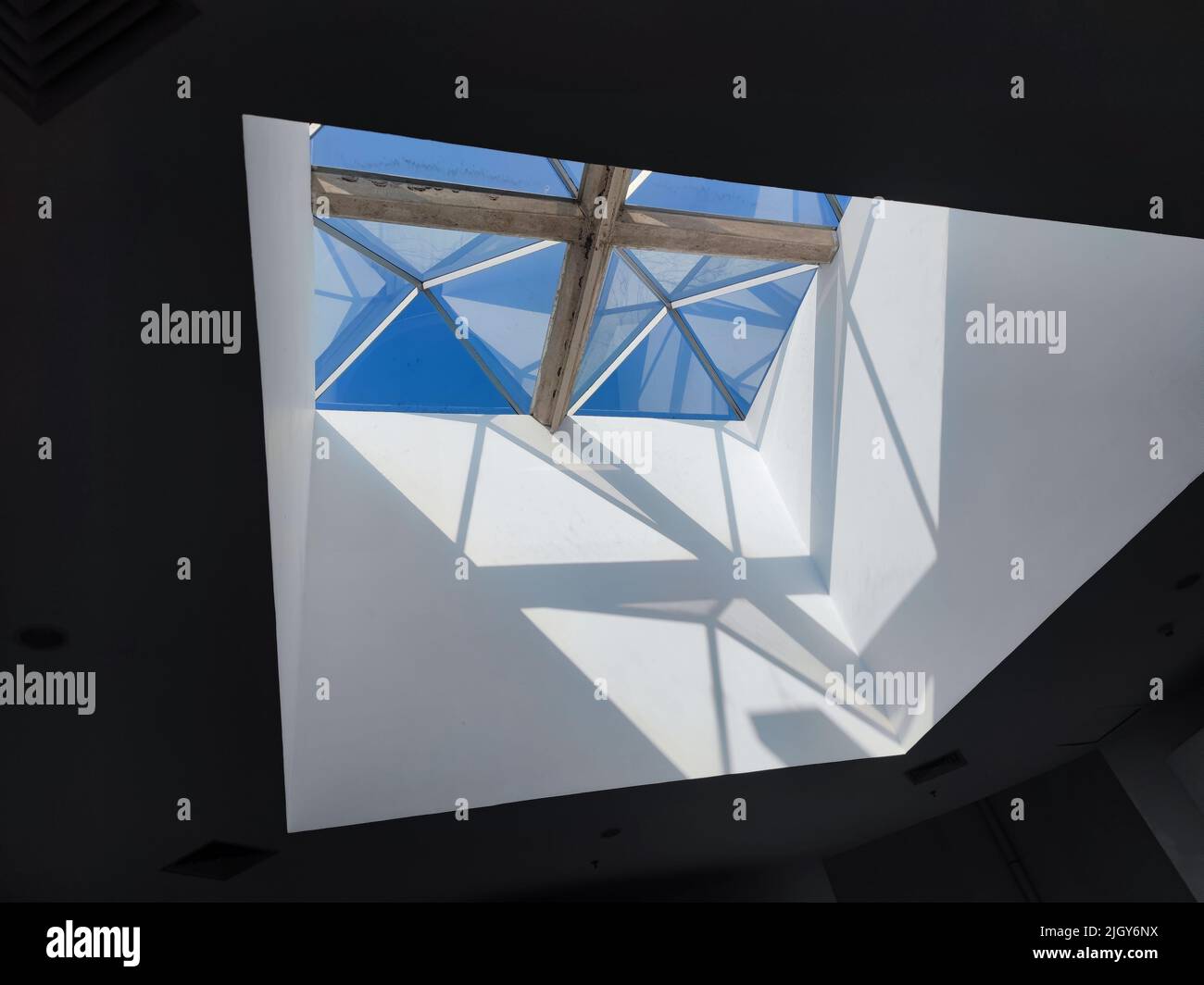 A low angle shot of a small wooden window in the ceiling of a black and ...